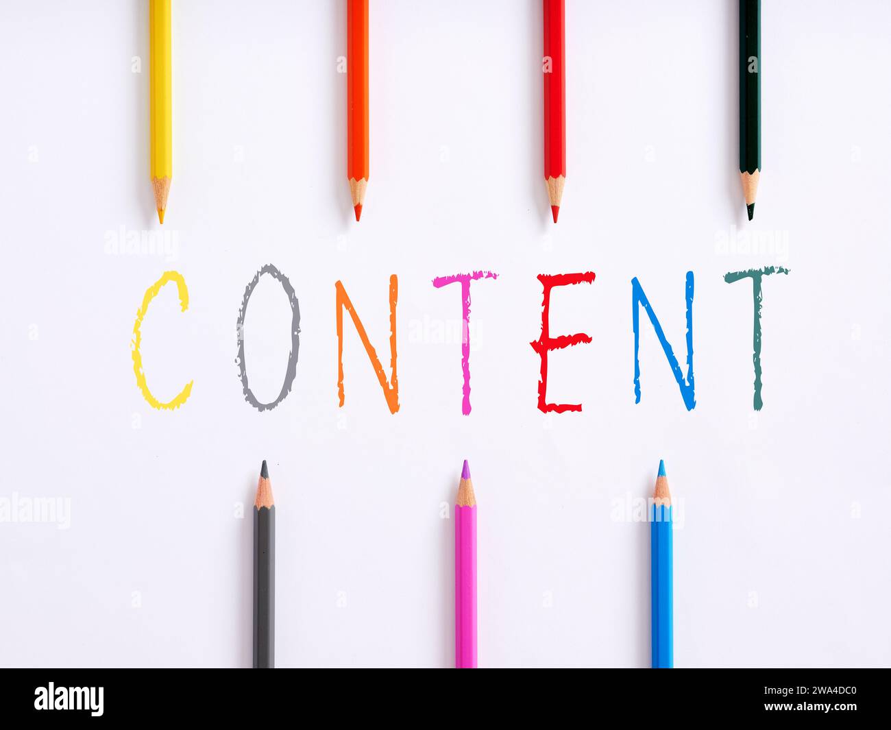 The handwritten word content and colorful crayons on white background ...