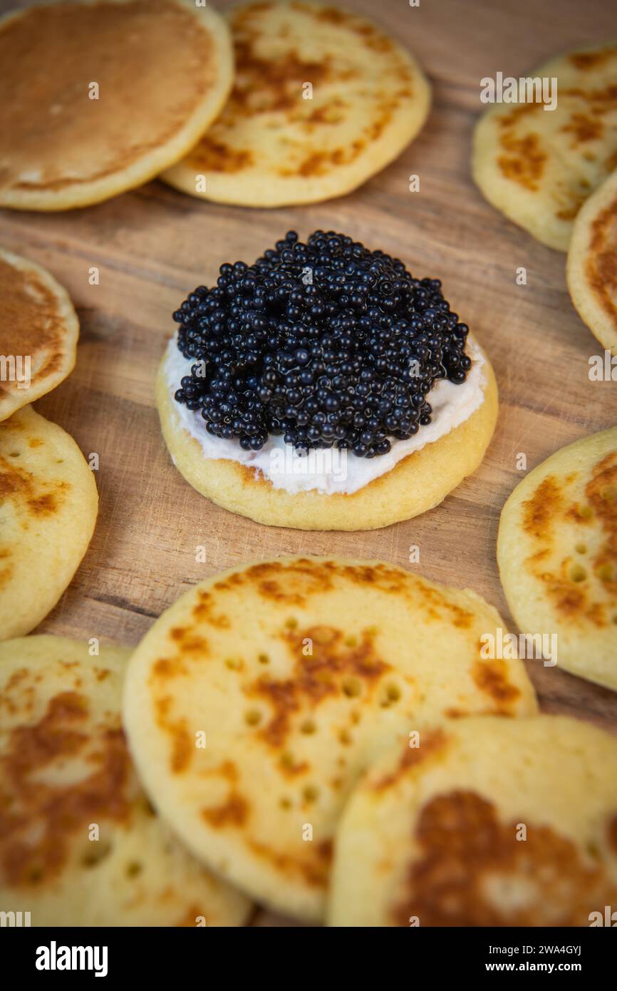 Blinis with black caviar and cream cheese, on a festive dish, mini ...