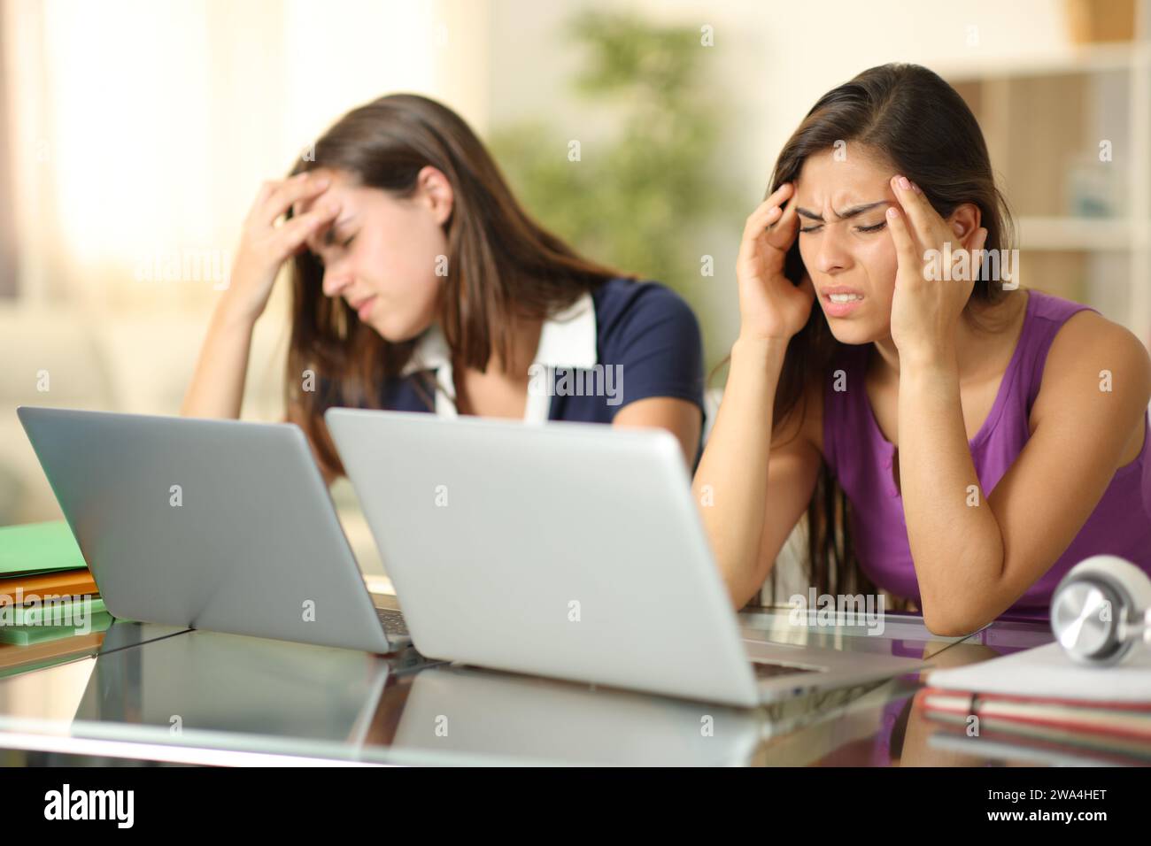 Two tired students suffering head ache e-learning at home Stock Photo ...