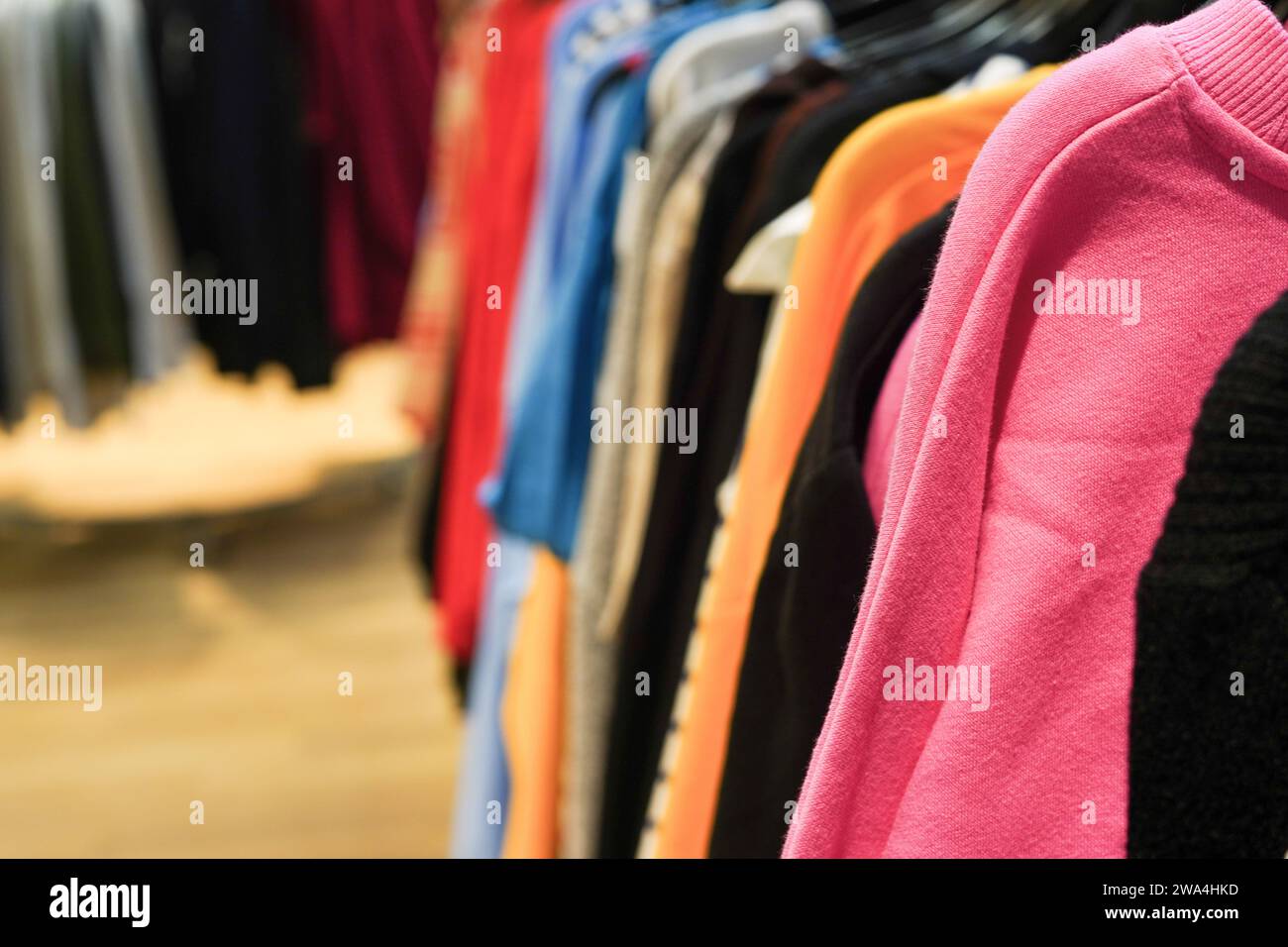 Second hand store with colorful clothes. Garage sale Stock Photo - Alamy