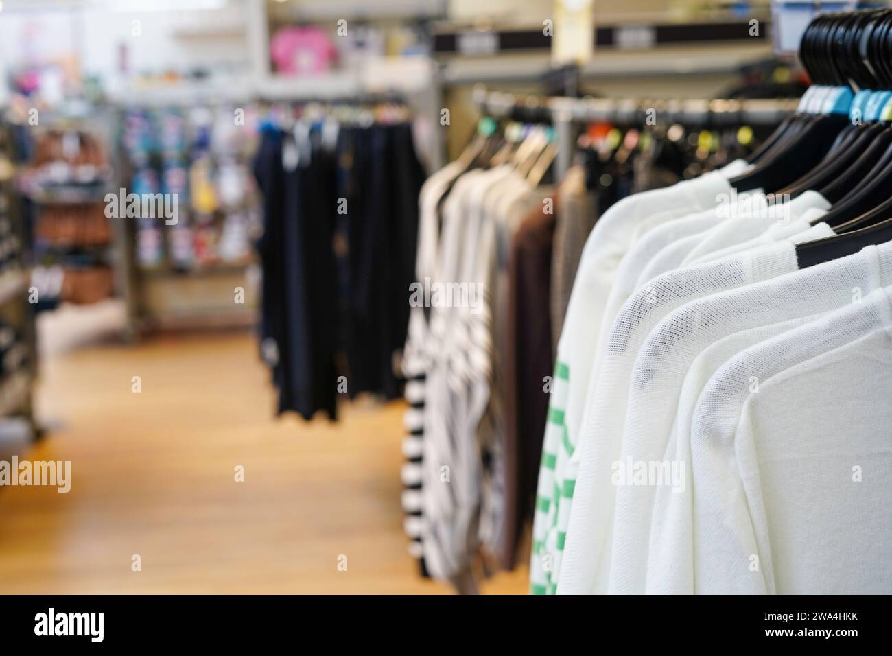 Stylish clothes on hangers in big shopping mall Stock Photo - Alamy