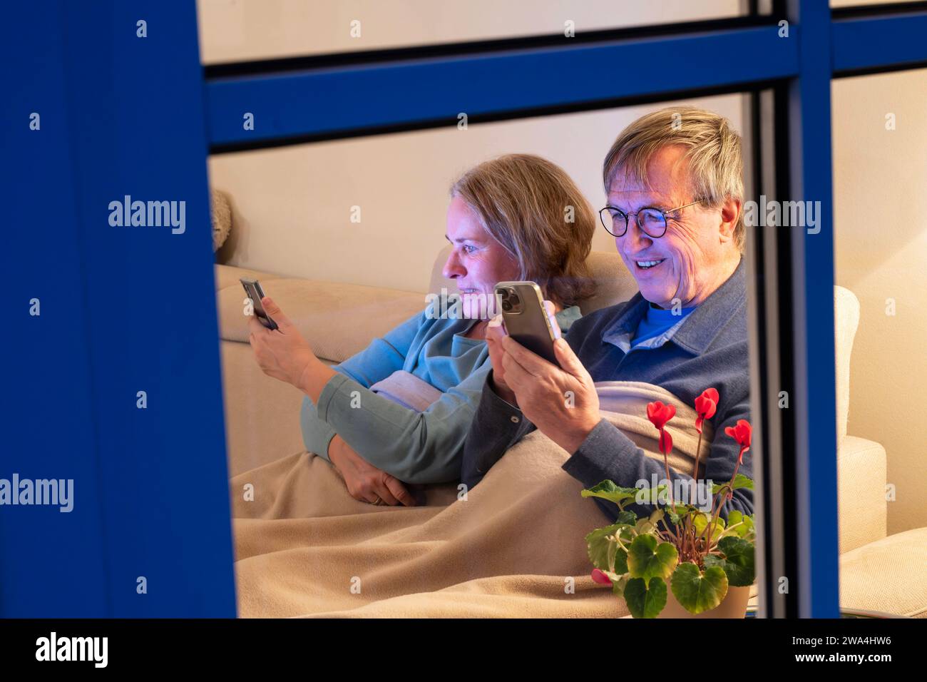 Seniorenpaar surft abends im Internet, beide sitzen mit ihren ...