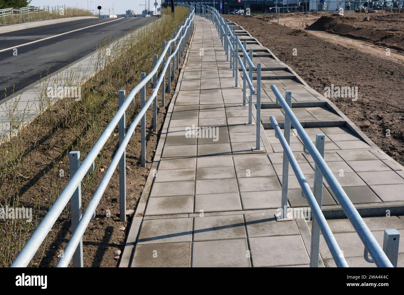 New concrete pedestrian and bicycle paths with a metal fence Stock ...