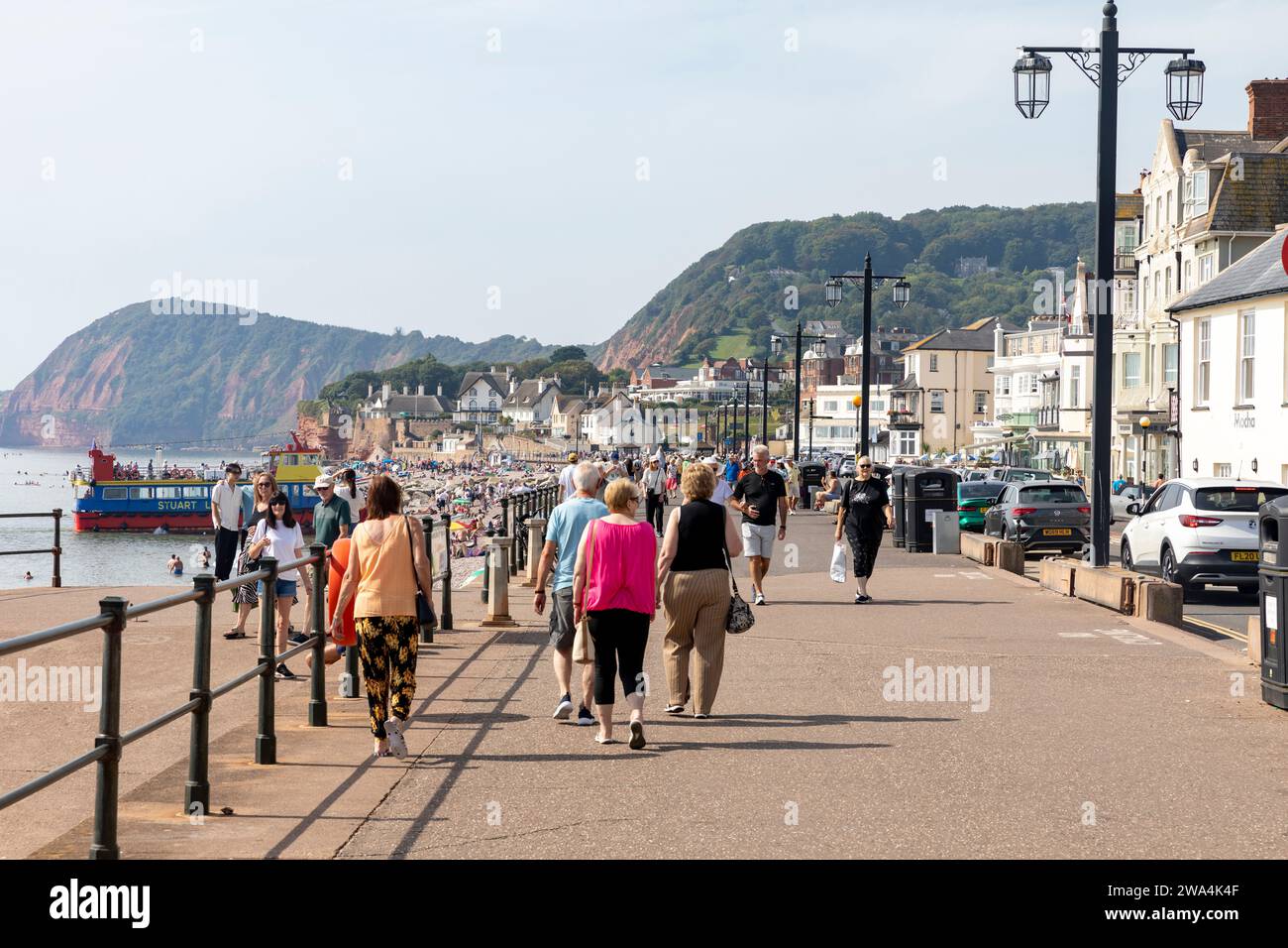 Sidmouth Dorset 2023, people walk along Sidmouth promenade beside the ...