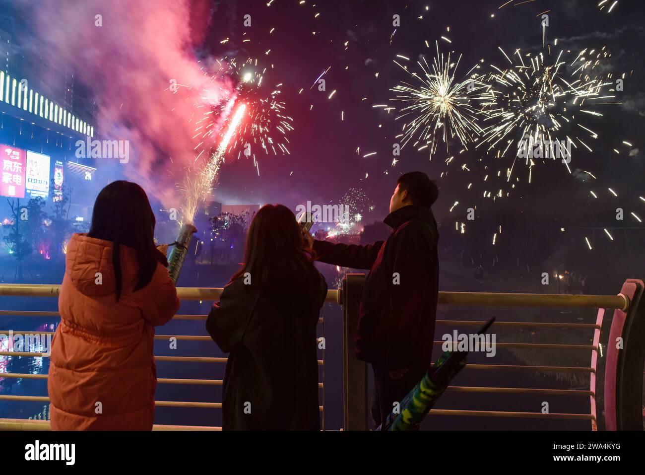 Fuyang, China. 01st Jan, 2024. People set off hand-held fireworks by a ...