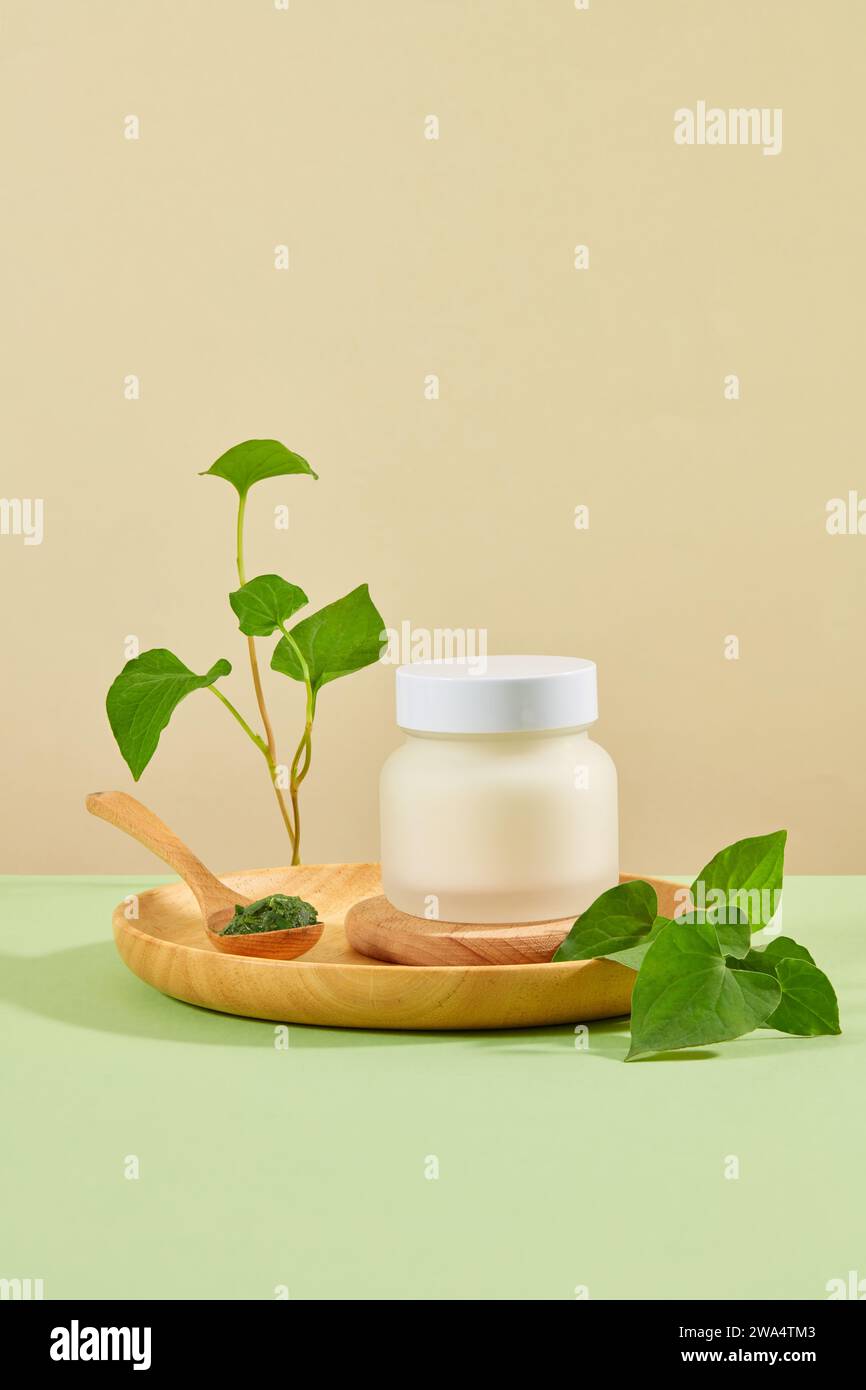 On the round wooden plate, white cosmetic jar decorated with fish mint ...