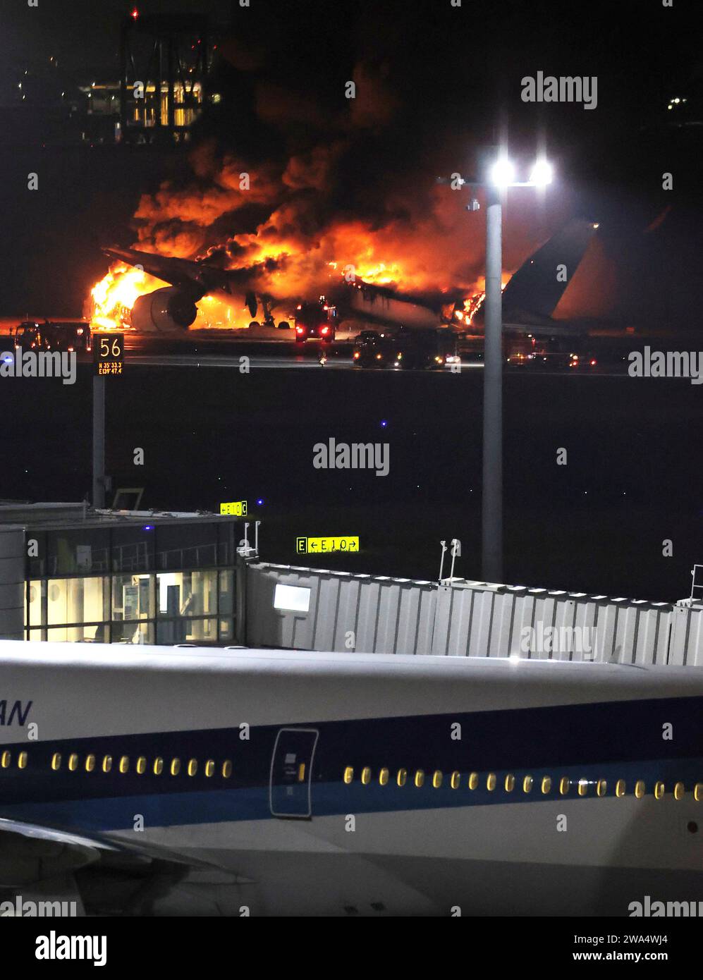 A Japan Airlines plane catches fire on the runway at Haneda Airport in ...