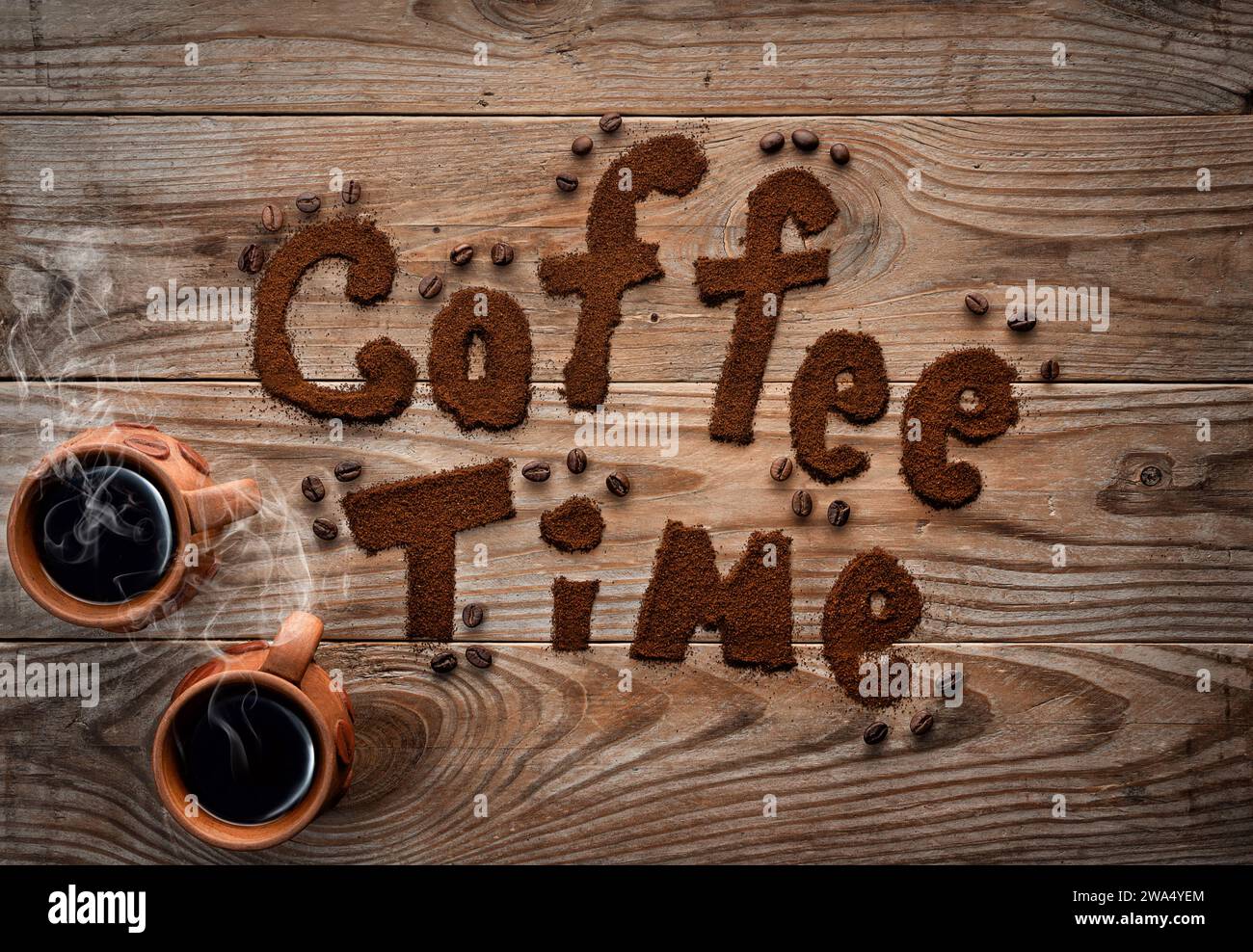 Coffee time written by ground coffee on textured wooden background. Two ...
