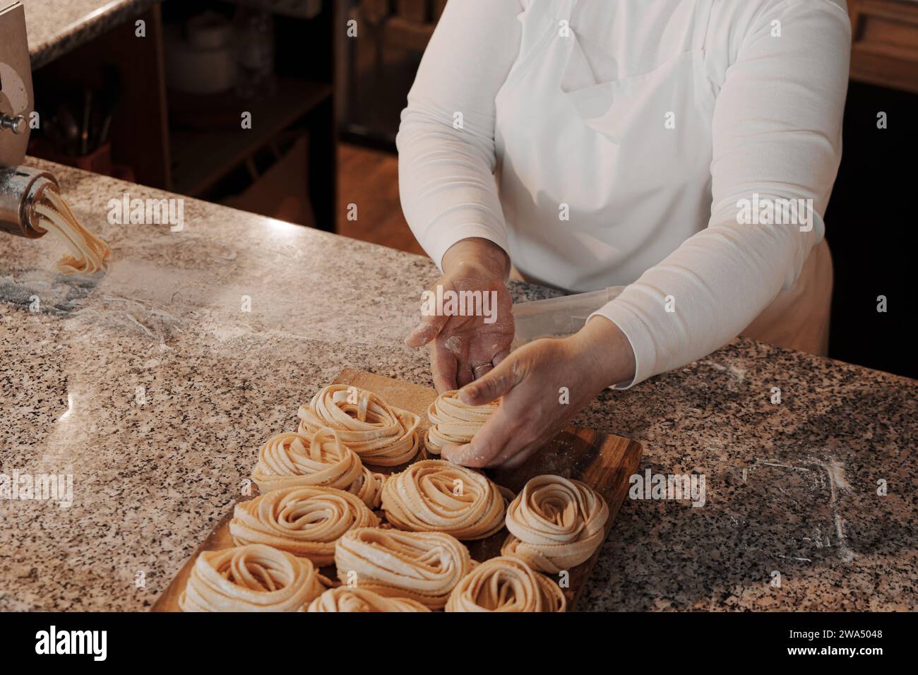 Crop housewife preparing homemade rolled tagliatelle pasta Stock Photo ...
