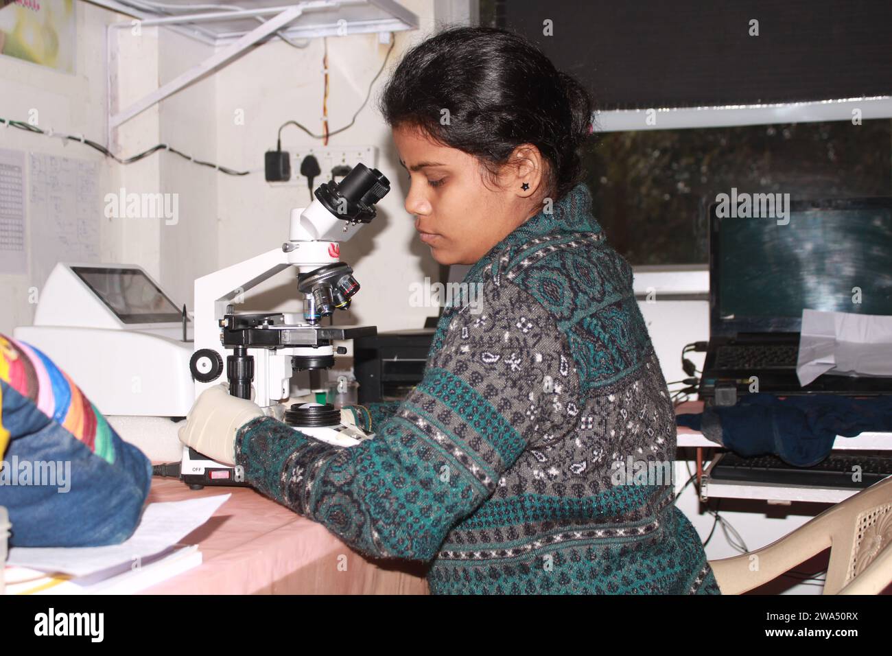 Lady pathologist examining with microscope. India Stock Photo - Alamy