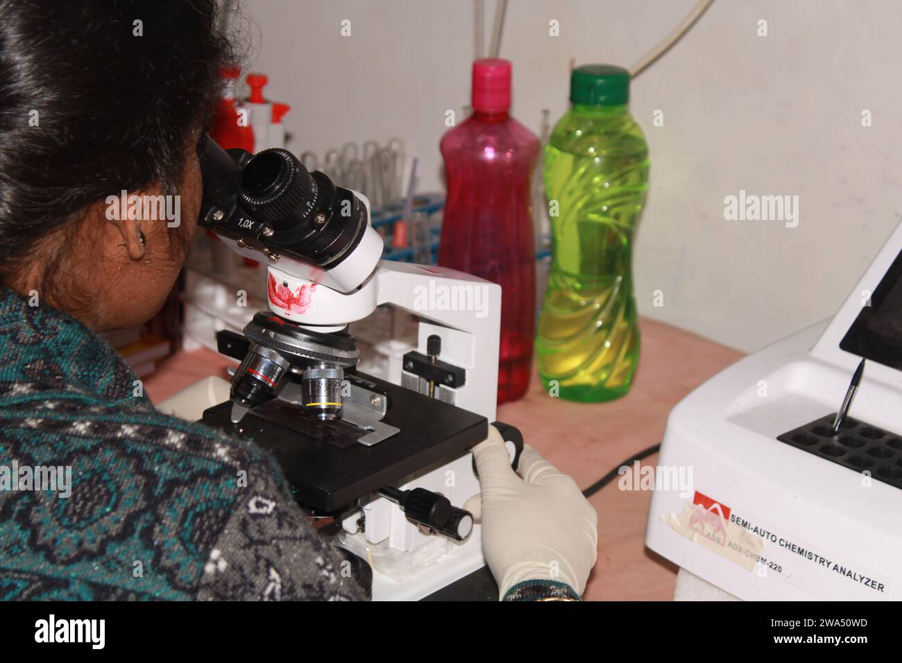 Lady pathologist examining with microscope. India Stock Photo - Alamy