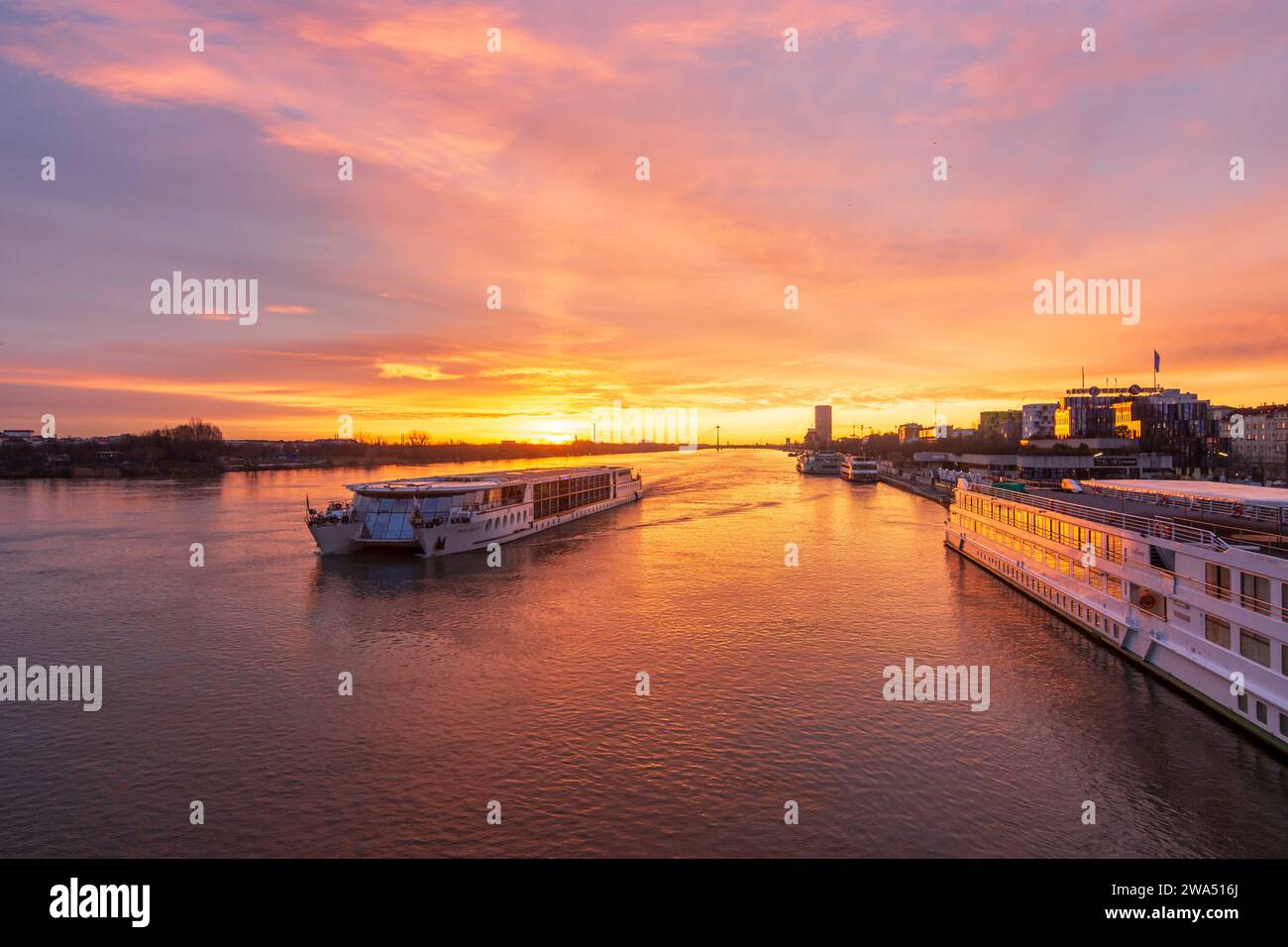 Vienna: river Donau (Danube) at sunrise, cruise ships, jetty, bridge ...