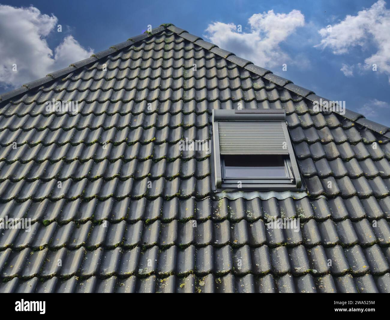 Open roof window in velux style with black roof tiles Stock Photo - Alamy
