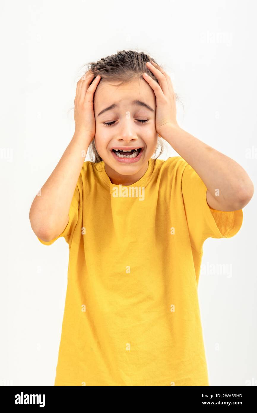Little desperate girl looking panic, holding her head with both hands ...