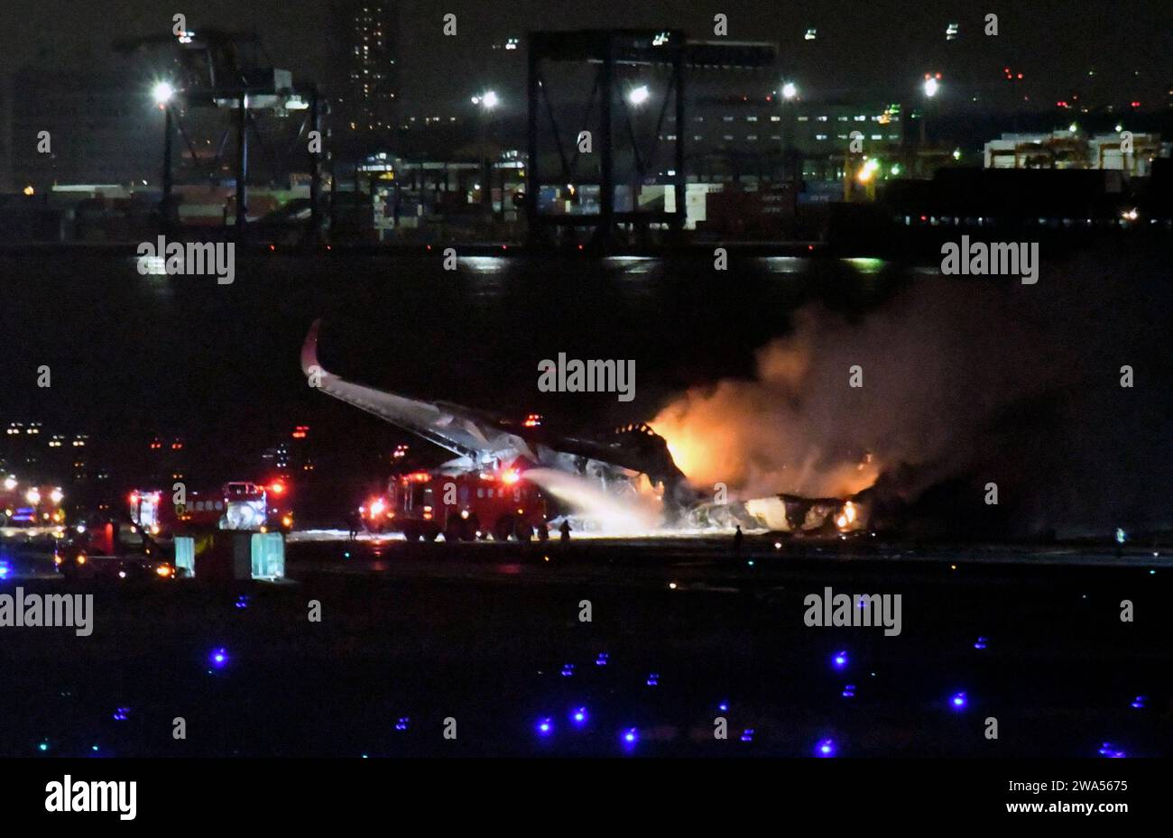 Tokyo, Japan. 02nd Jan, 2024. Firefighters work at the site of an ...