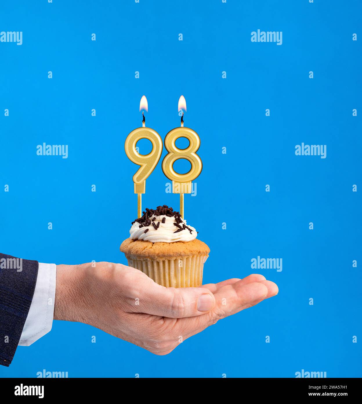Hand delivering birthday cupcake - Candle number 98 on blue background ...