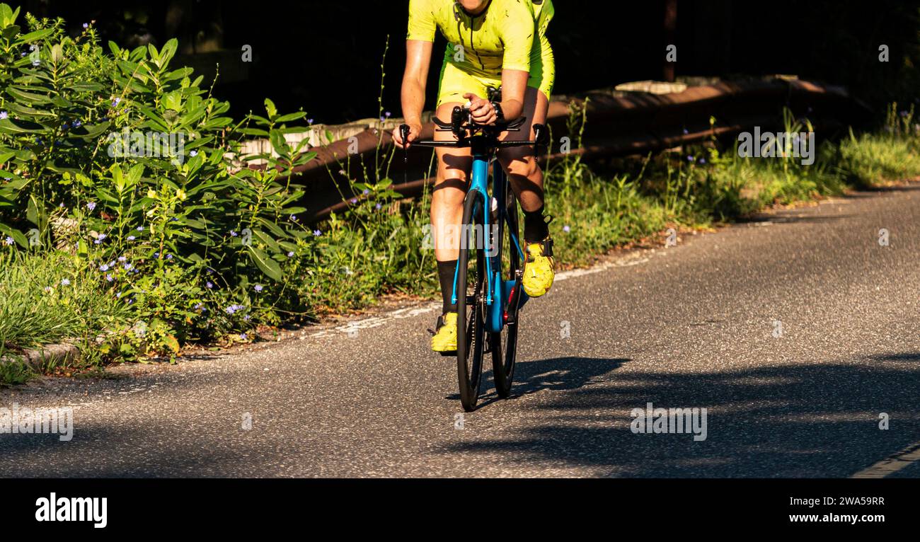 Front view of a person riding a racing bike down a road Stock Photo - Alamy