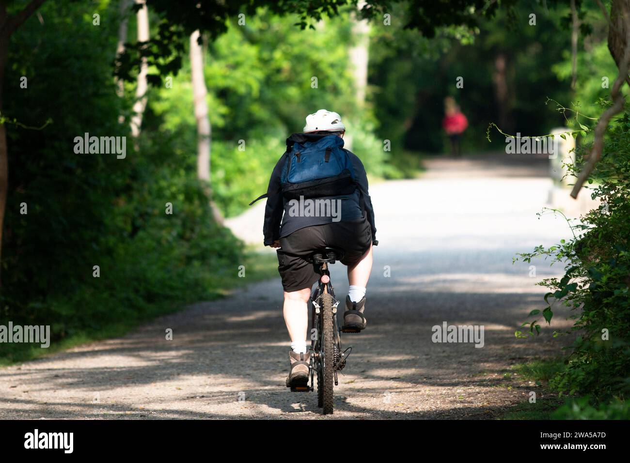 Person riding bike down hi-res stock photography and images - Alamy