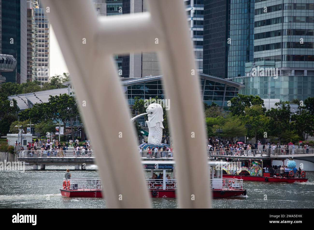 Merlion sprouting through the gap while the bum boats past across the ...
