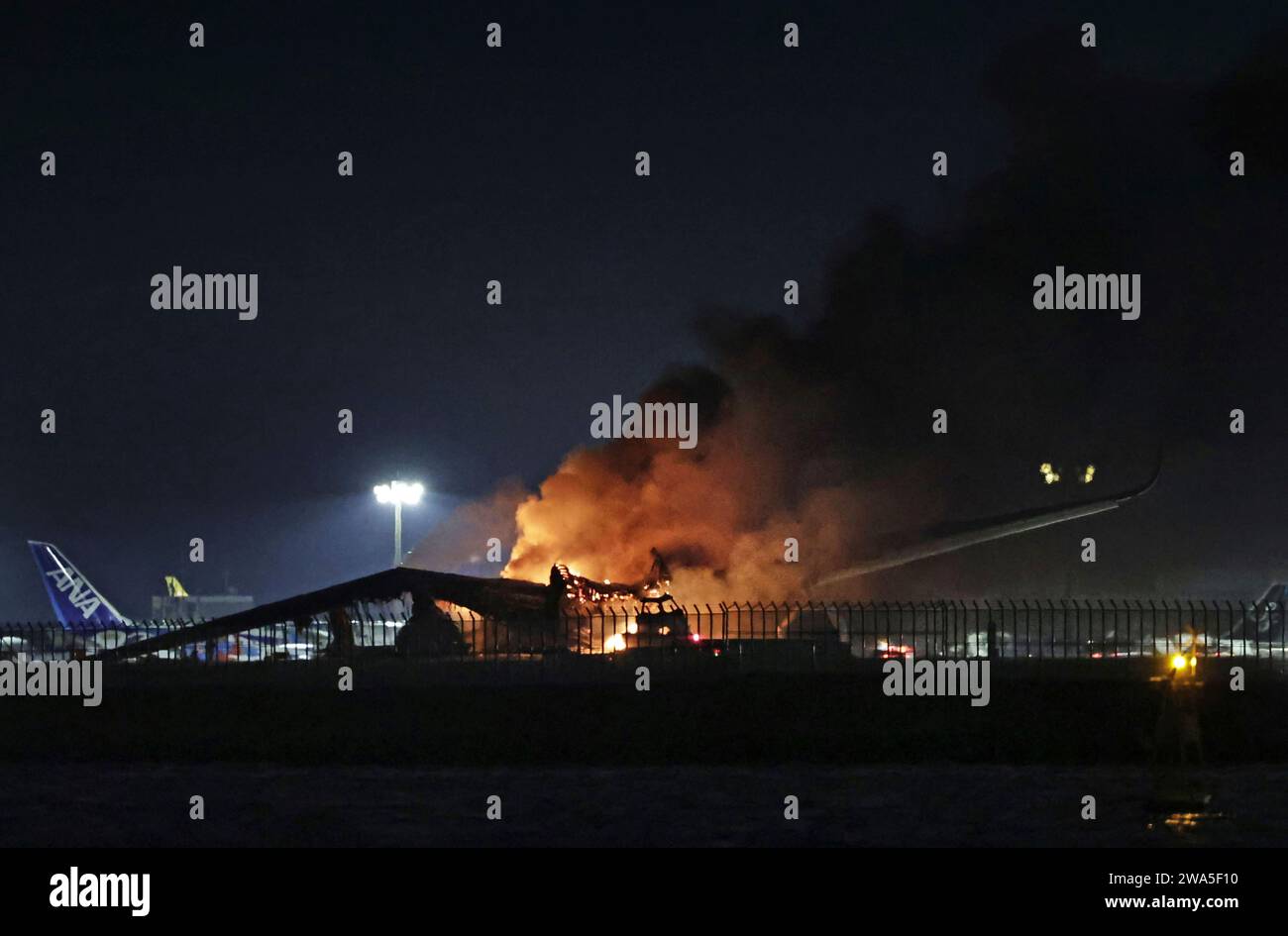 A Japan Airlines plane on fire on the runway of Haneda airport on ...