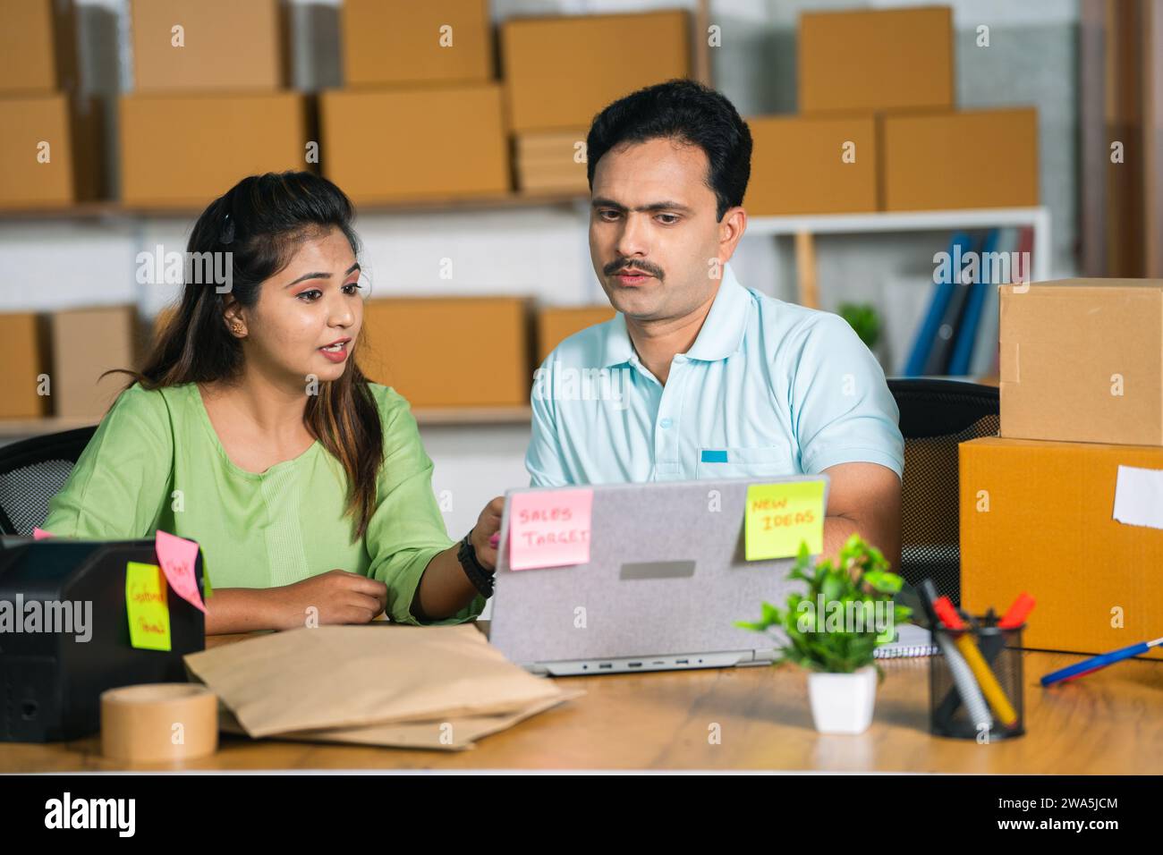 Indian coworkers or couples discussing from laptop while working ...