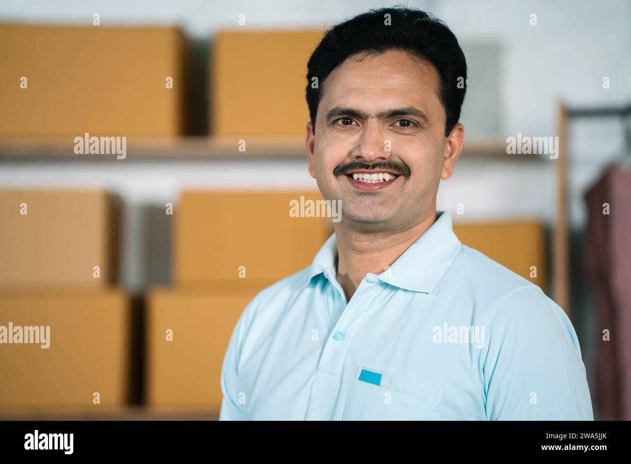 Happy indian confident small businessman at merchandise wear house ...