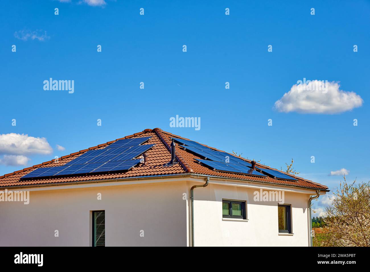 Solar panels on a home with a hipped roof and blue sky Stock Photo - Alamy