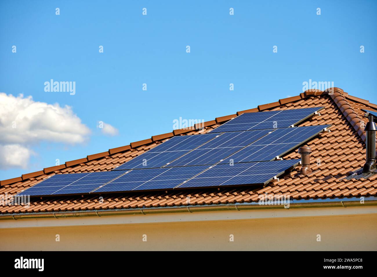 Solar system on hipped roof against blue sky Stock Photo - Alamy