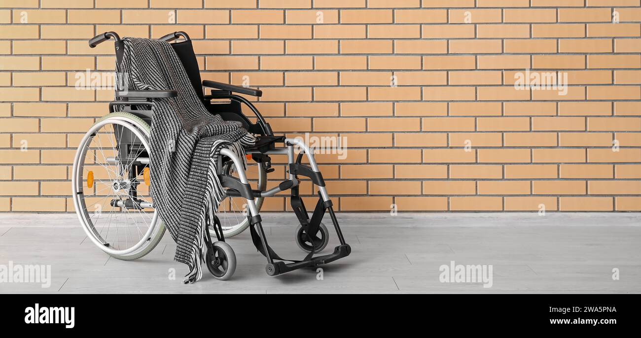 Modern wheelchair with plaid near brick wall. Banner for design Stock ...