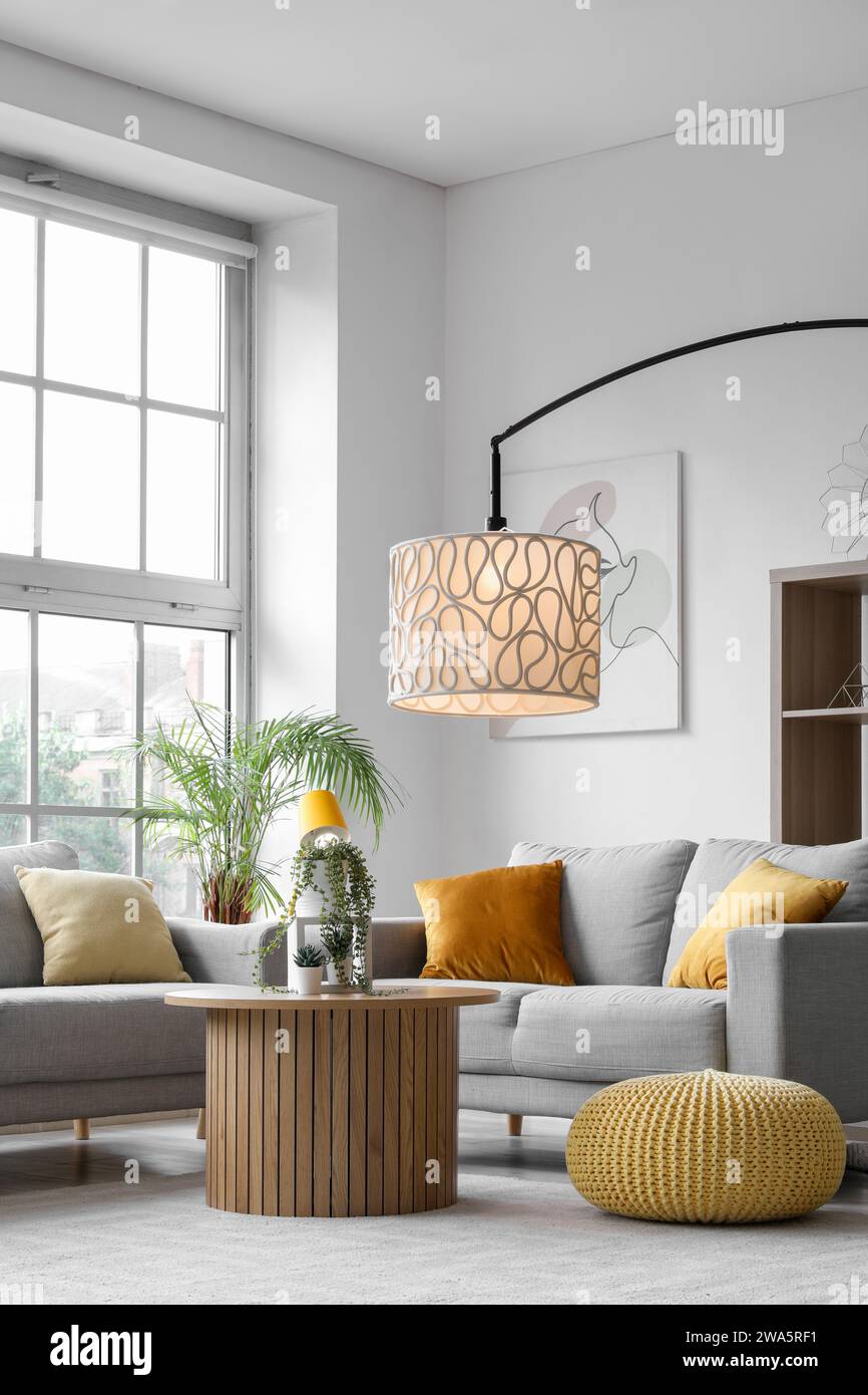 Interior of light living room with cozy grey sofas, coffee table and ...