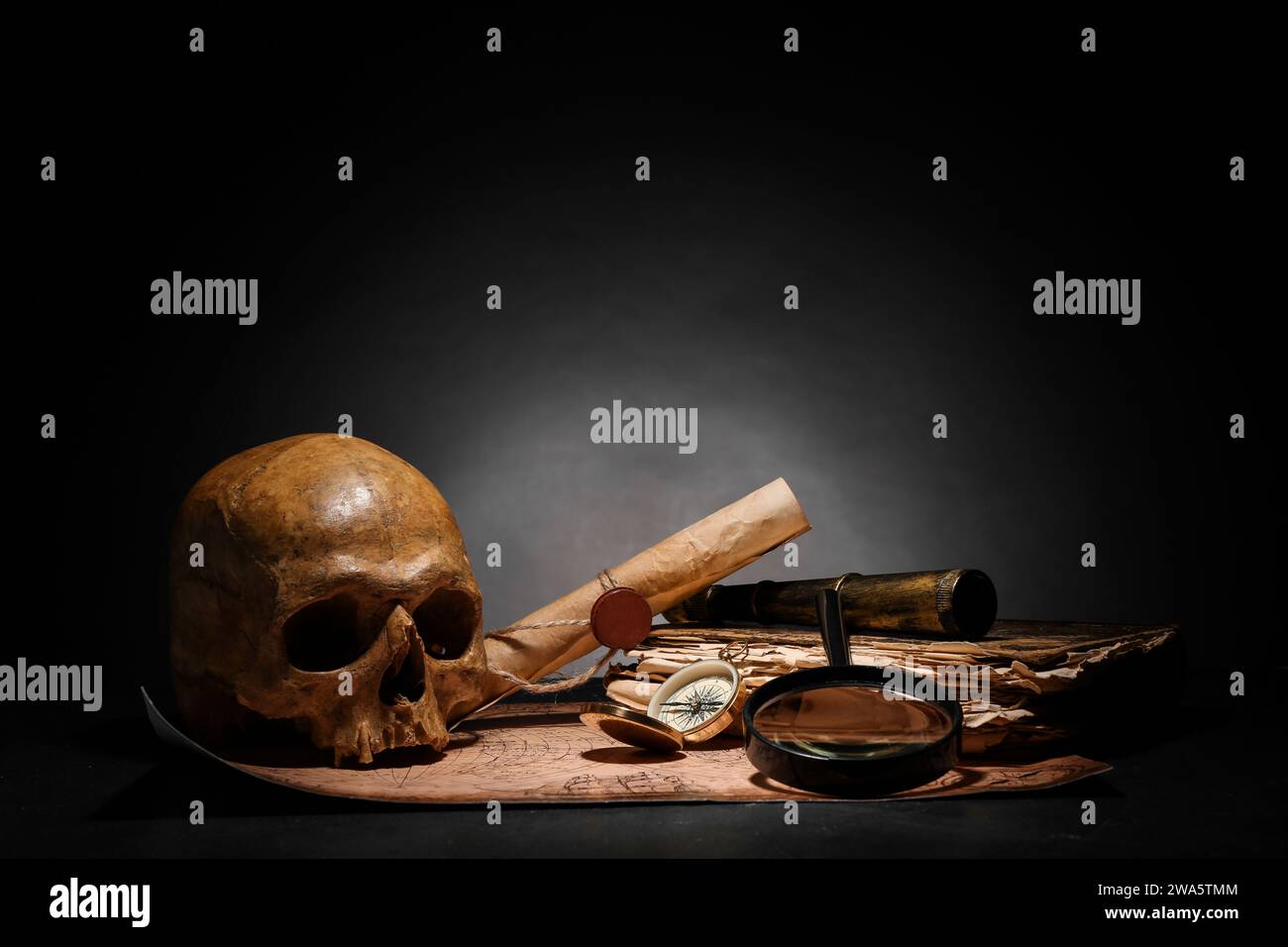 Human skull with old manuscripts, travel equipment and world map on ...