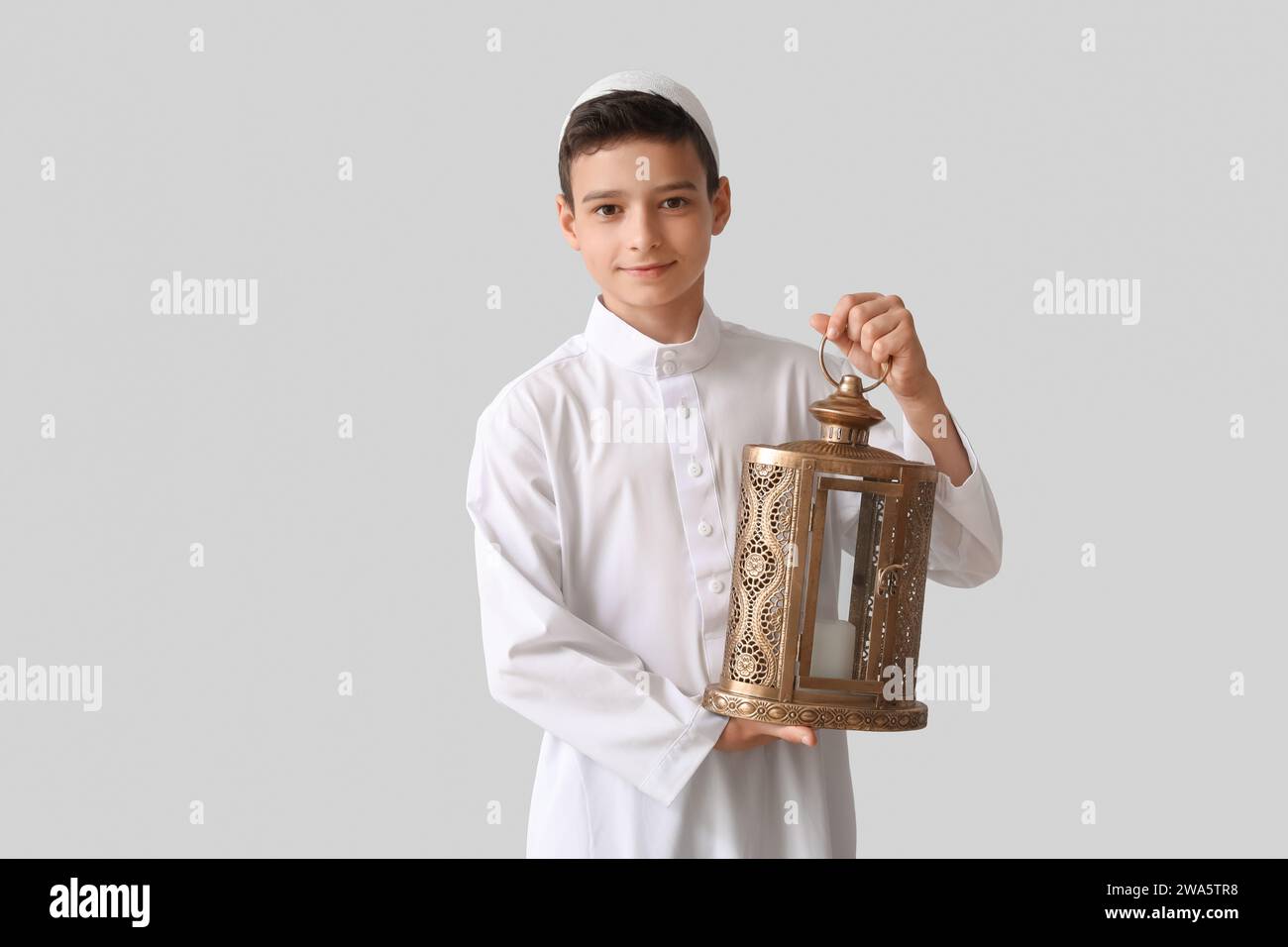 Little Muslim boy with fanous lantern on light background Stock Photo ...