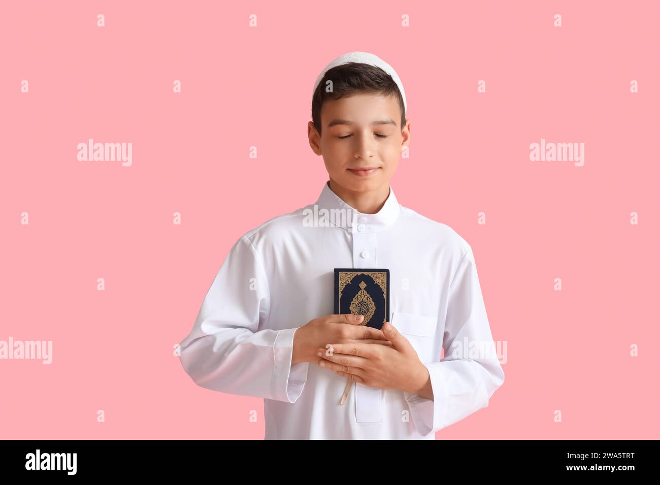 Little Muslim boy with Quran on pink background Stock Photo - Alamy