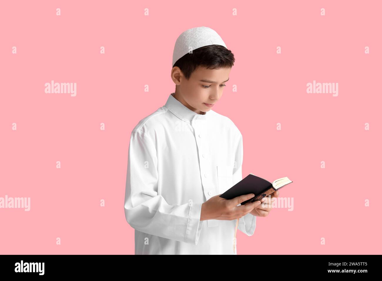 Little Muslim boy with Quran on pink background Stock Photo - Alamy