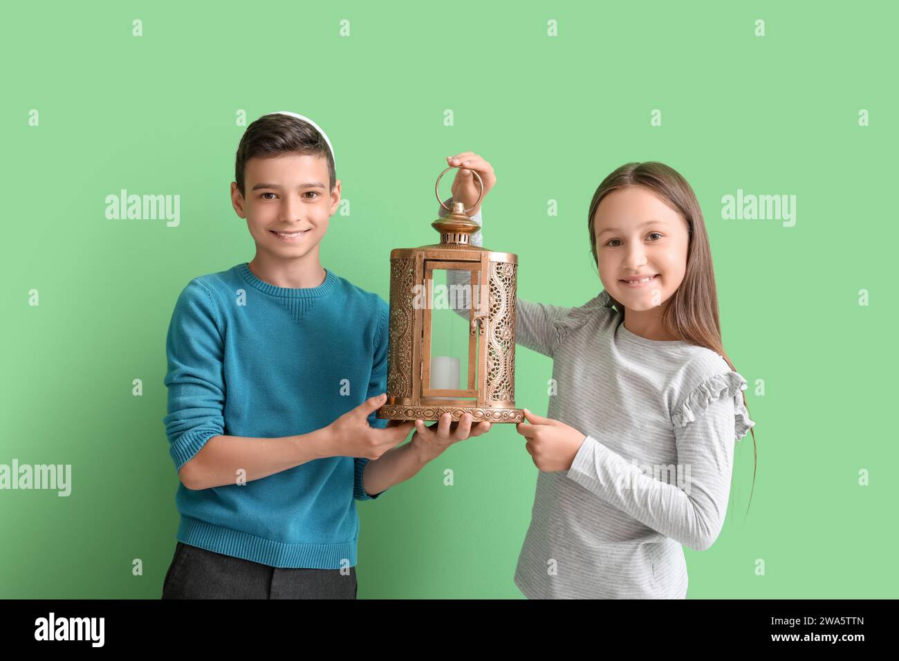 Little Muslim children with fanous lantern on green background Stock ...