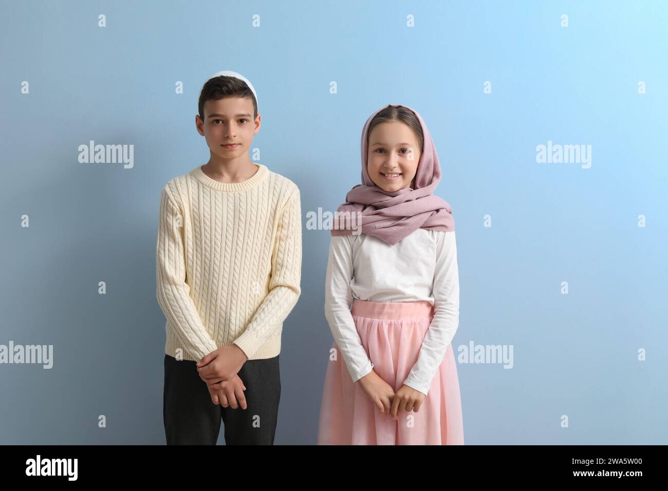 Little Muslim children on light blue background Stock Photo - Alamy
