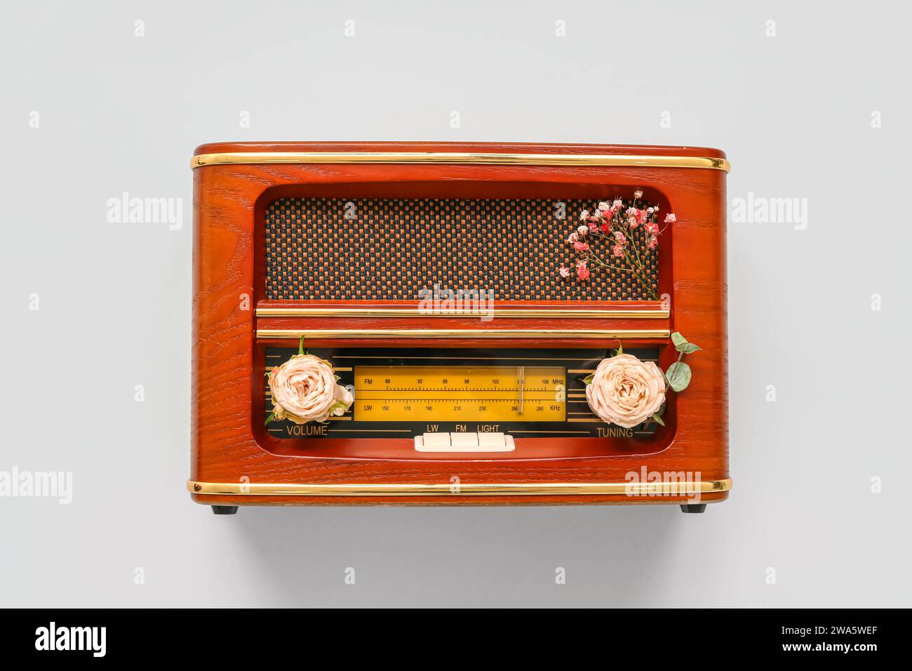 Retro radio with beautiful flowers on light background Stock Photo - Alamy