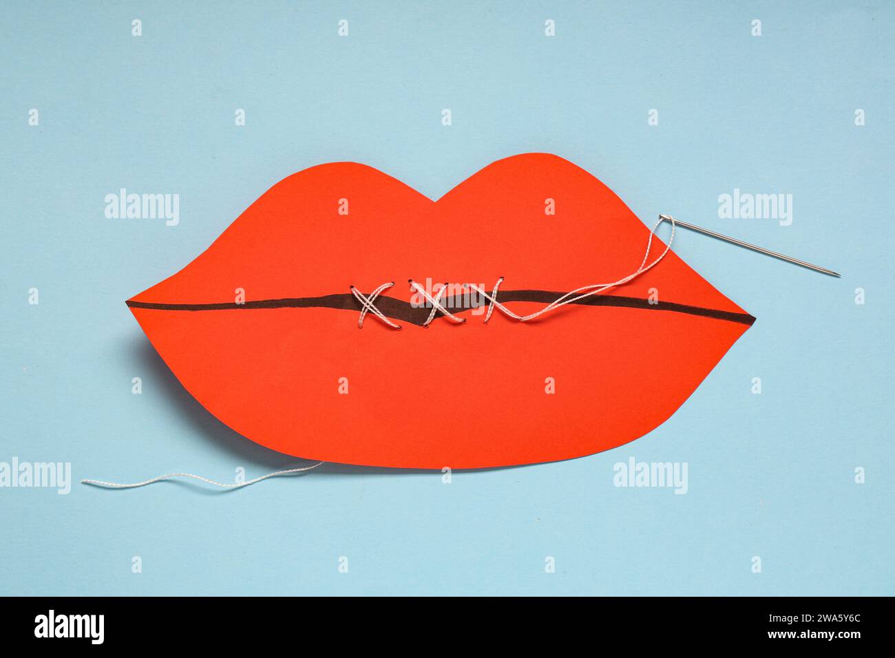 Sewn paper lips on blue background. Domestic violence concept Stock ...