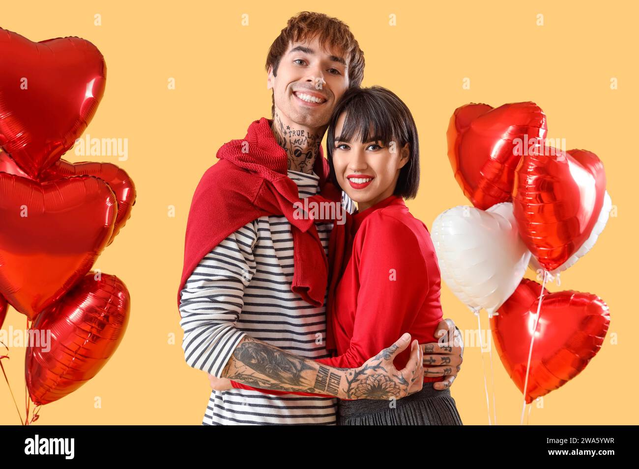 Young couple hugging and balloons on yellow background. Valentine's Day ...