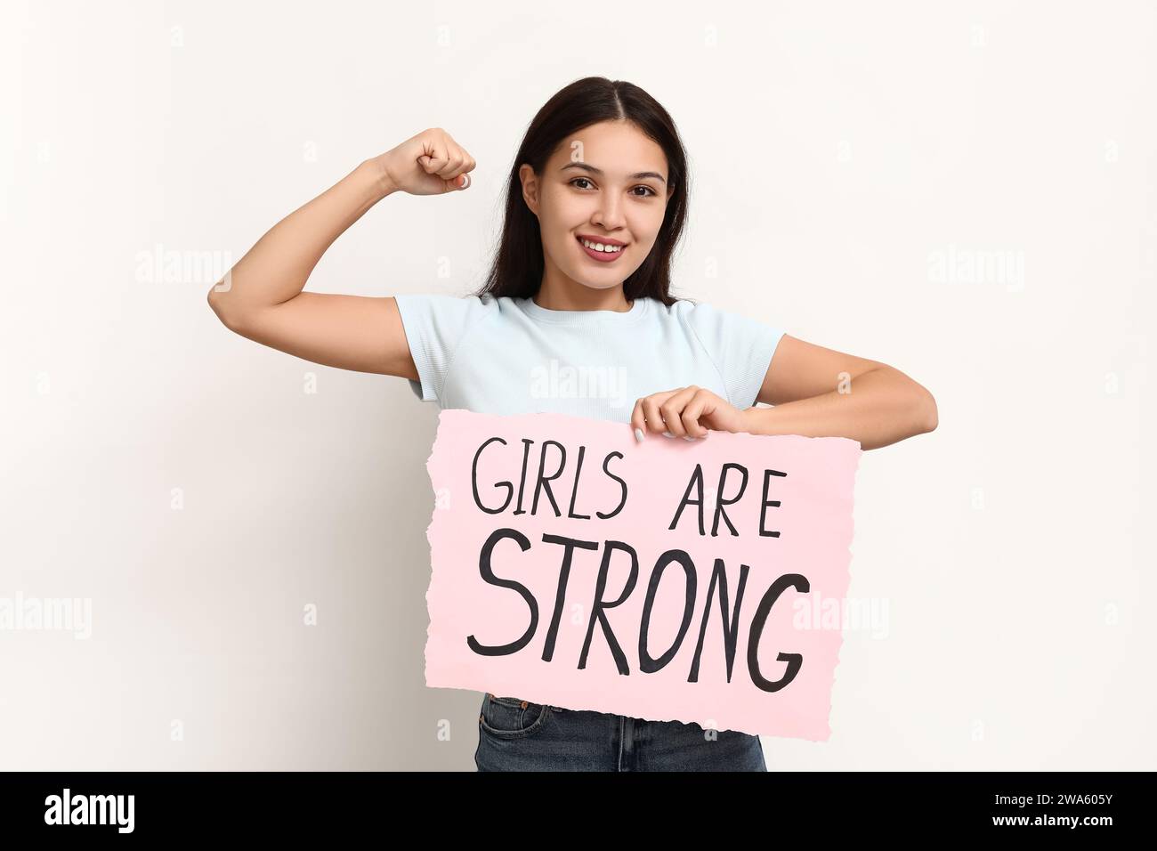Young woman with sign GIRLS ARE STRONG on white background. Feminism ...