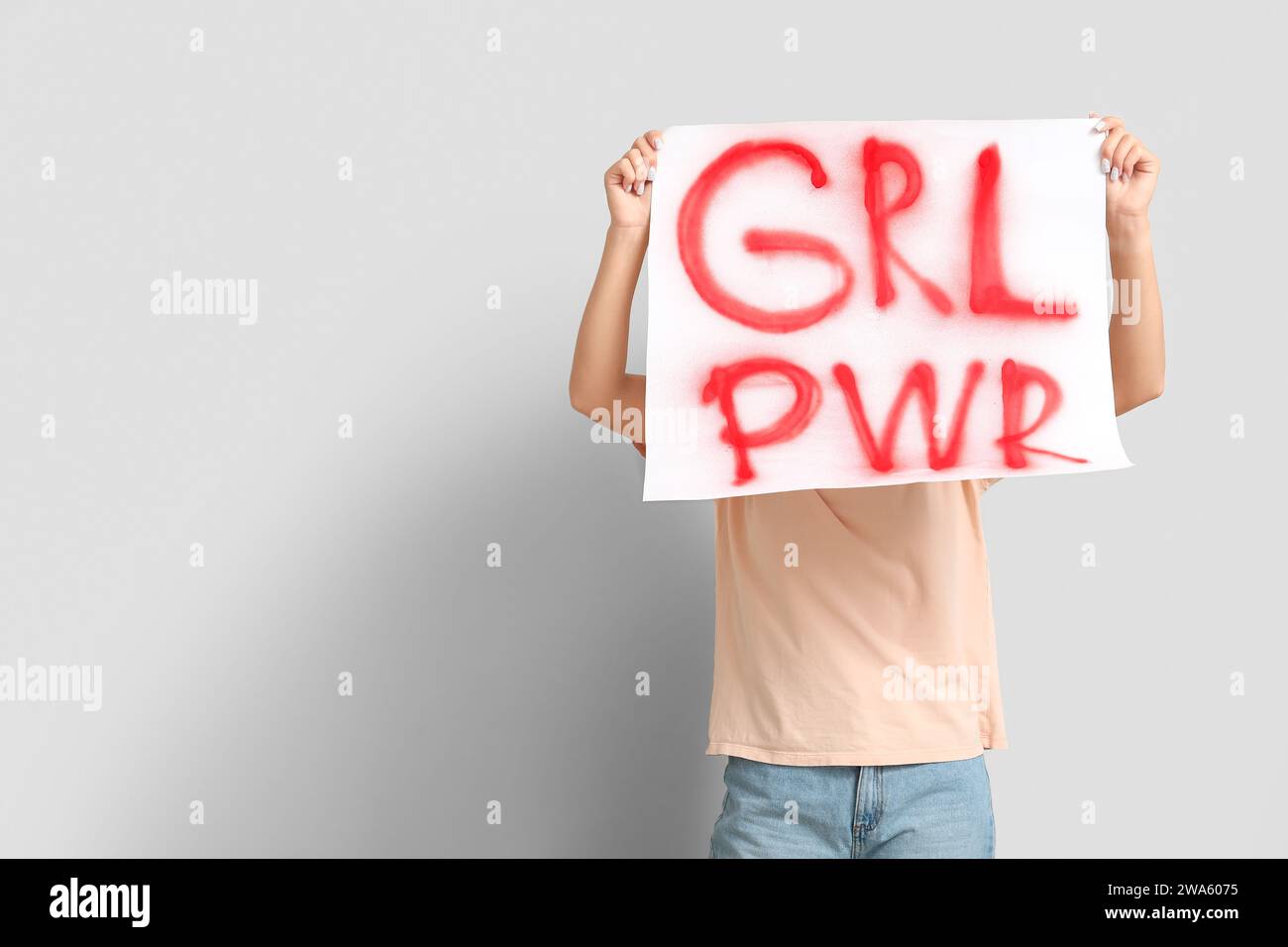 Woman covering face with sign GRL PWR on white background. Feminism ...