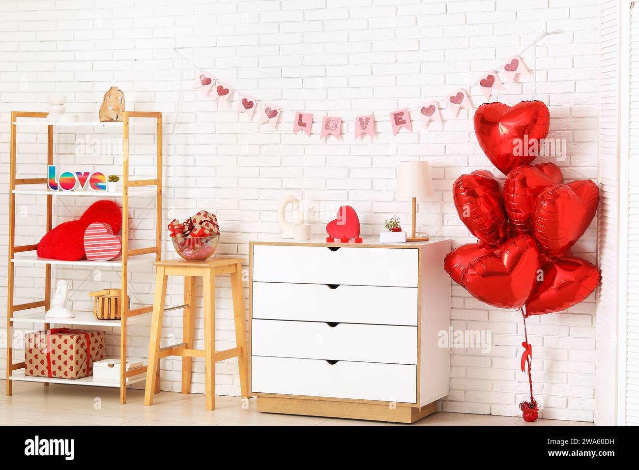 Heart-shaped balloons and bunting with word LOVE in living room ...