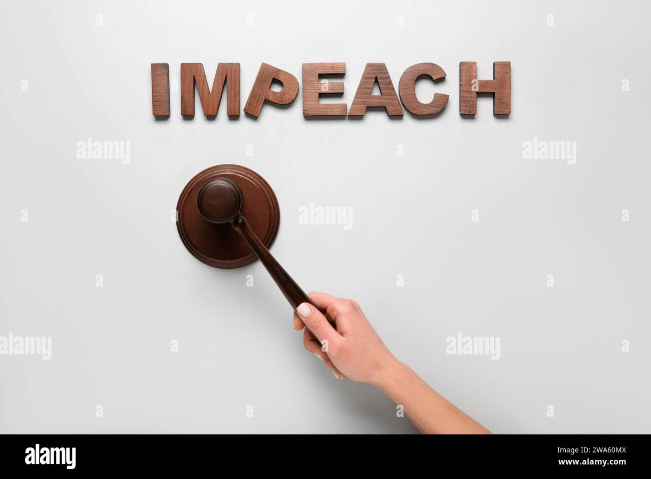Female hand with judge gavel and word IMPEACH on white background Stock ...