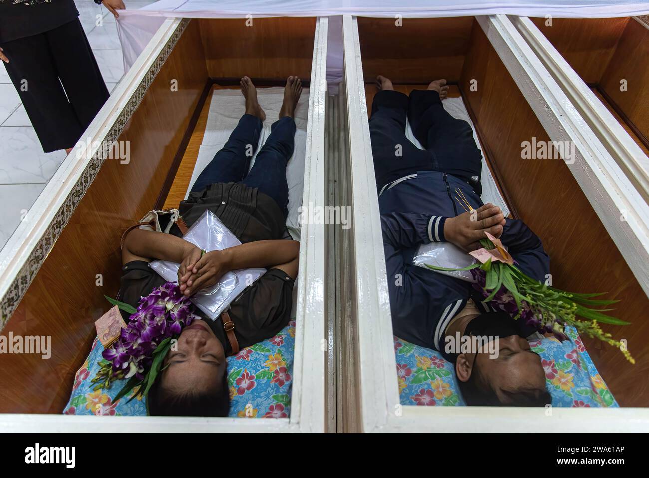 Bangkok, Thailand. 02nd Jan, 2024. Buddhist devotees lay inside coffins ...