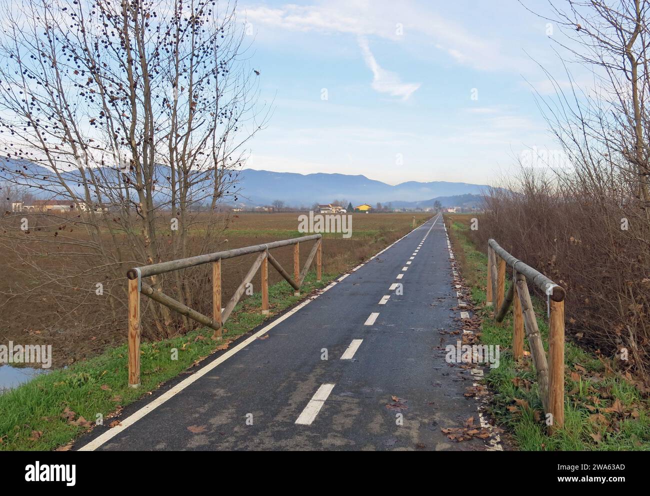 long asphalted cycle path in the middle of the plain without people ...
