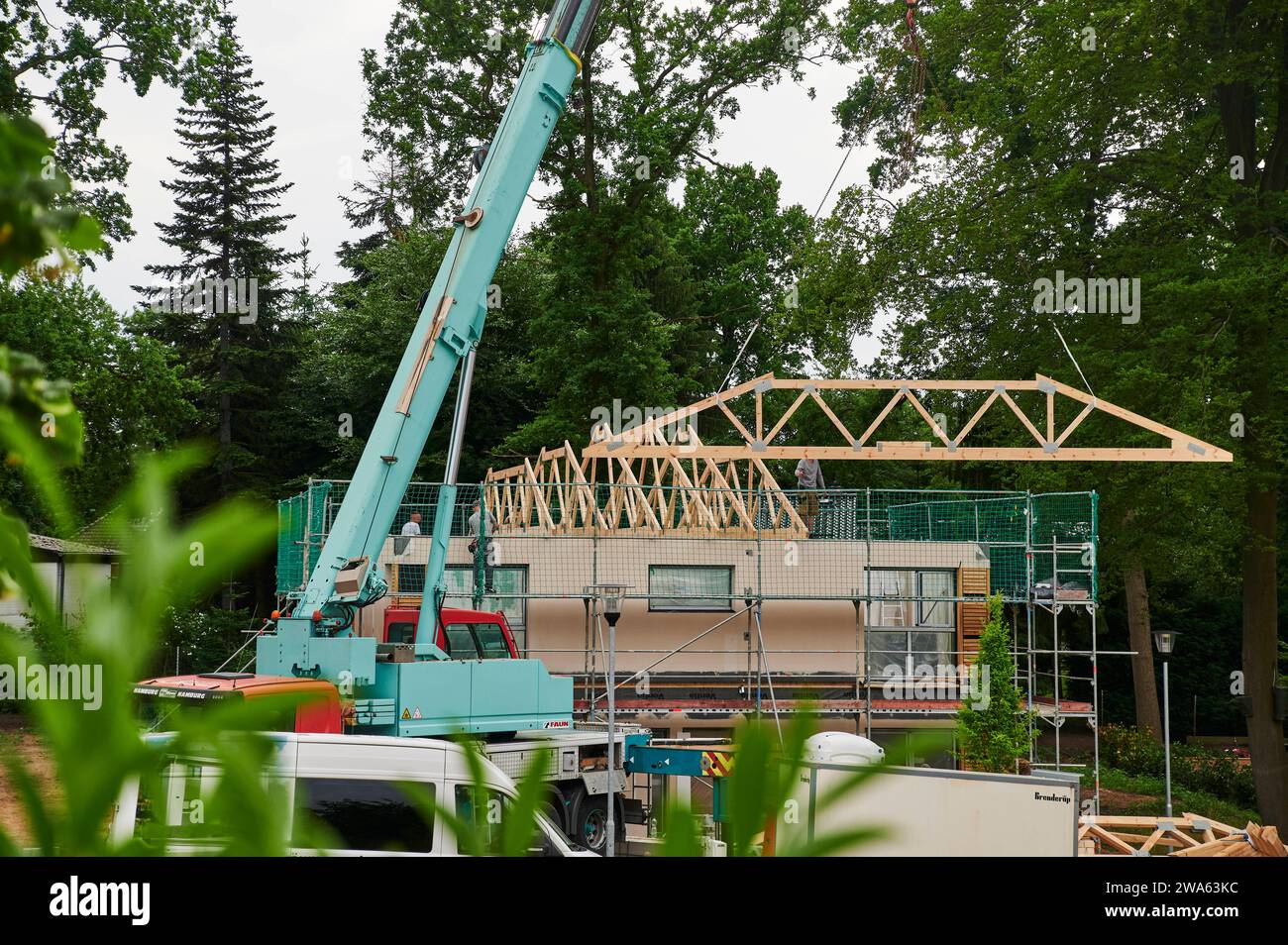 Bauhandwerk, Hausbau, Kran hebt Holzständerteile auf Rohbau für die ...