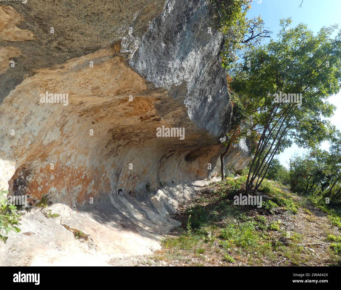 cave dug into the rock used in prehistory by primitive men as a shelter ...