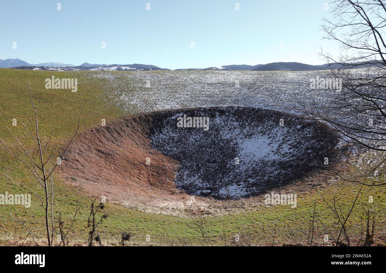 large depression in the terrain with snow in the mountains caused by ...