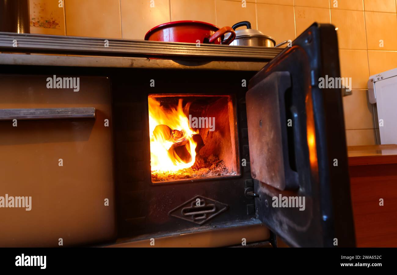 fire lit in the old wood stove of the economic kitchen and some pots ...