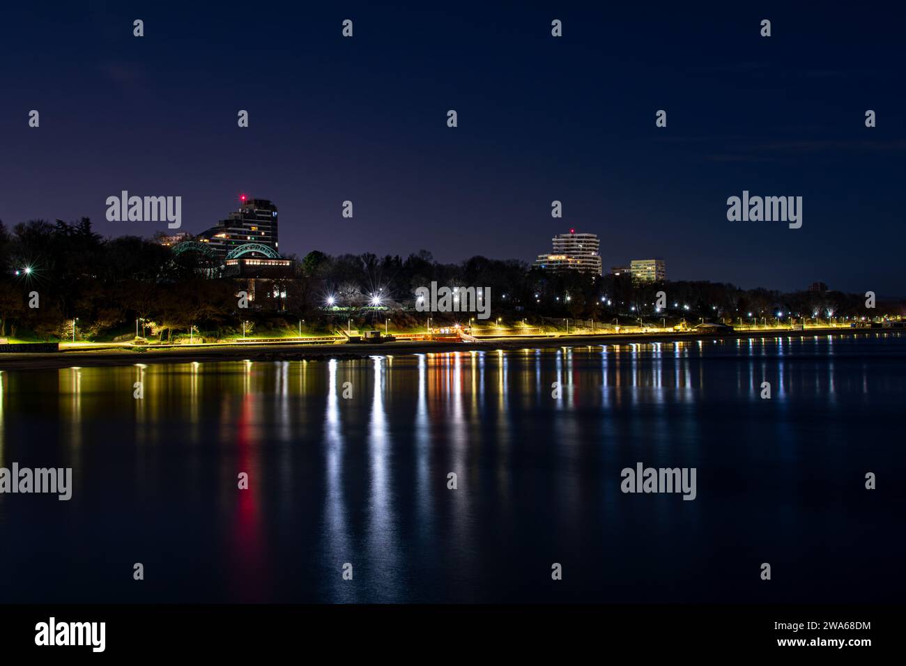 Beach alley at night, beautiful colorful lights reflecting in the water ...